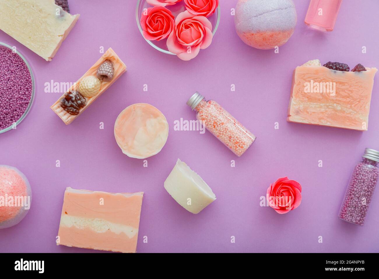 Handmade pink colorful soap spa bath products pattern on purple ...