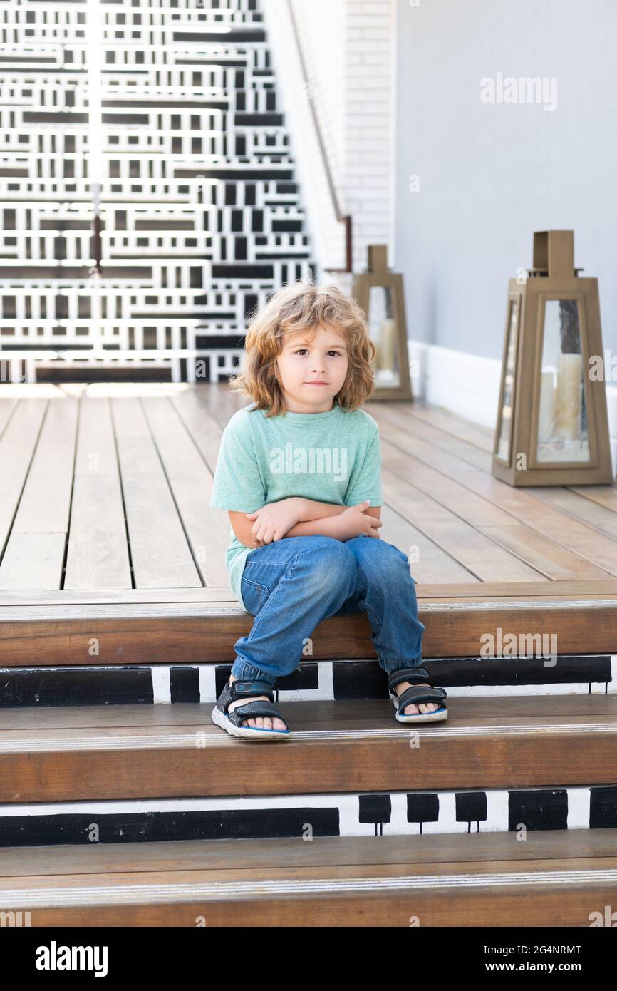 Serious boy kid take rest sitting on stairs, child Stock Photo - Alamy