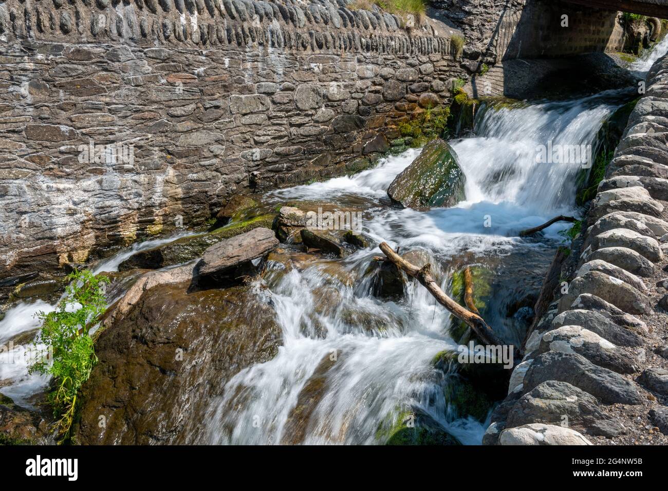 Long exposure of a waterfall flowing onto Lee Abbey Beach in Devon ...