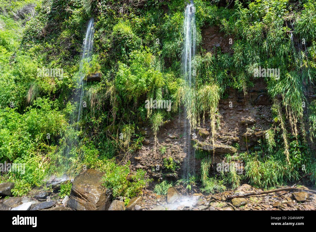 Long exposure of a waterfall flowing out of the cliff onto Lee Abbey ...