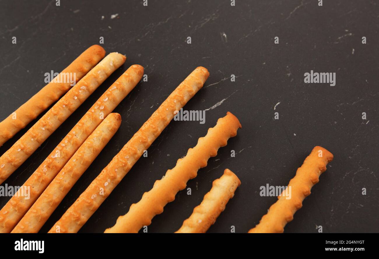 Salted grissini, also known as breadsticks on black marble like table ...