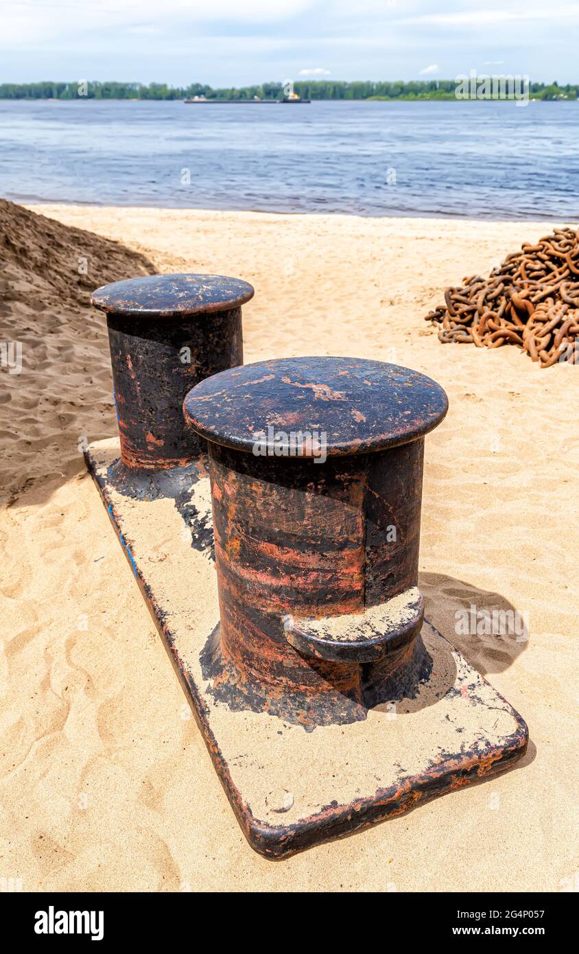 Old rusty mooring bollard in the harbor on the sand beach Stock Photo ...