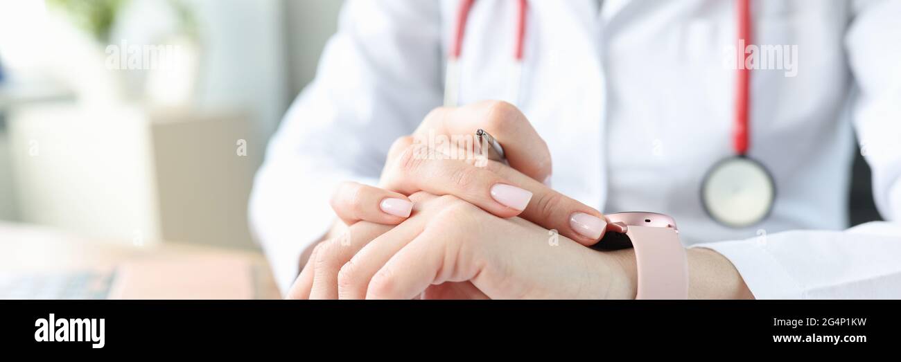 Doctor looks at clock at work table in medical office Stock Photo - Alamy