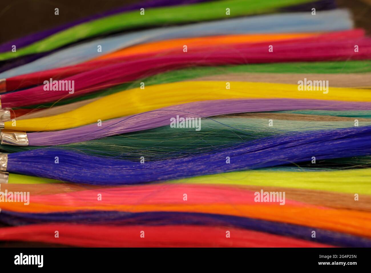 strands of natural dyed hair of bright colors in the palette on the ...