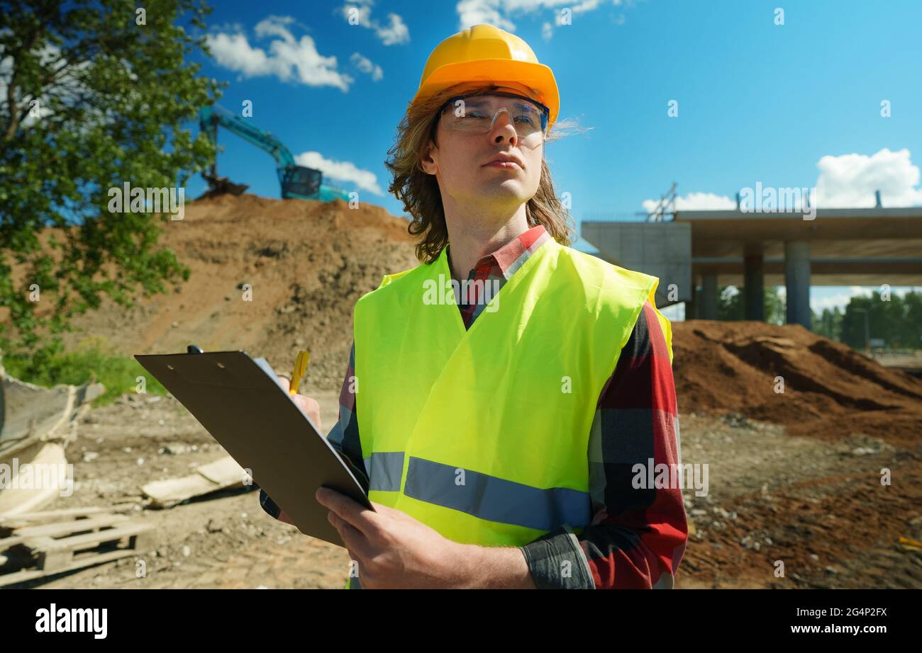 Builder with documents on the background of a road junction ...