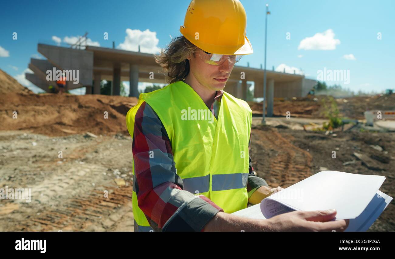 Construction engineer with documents on road junction construction site ...