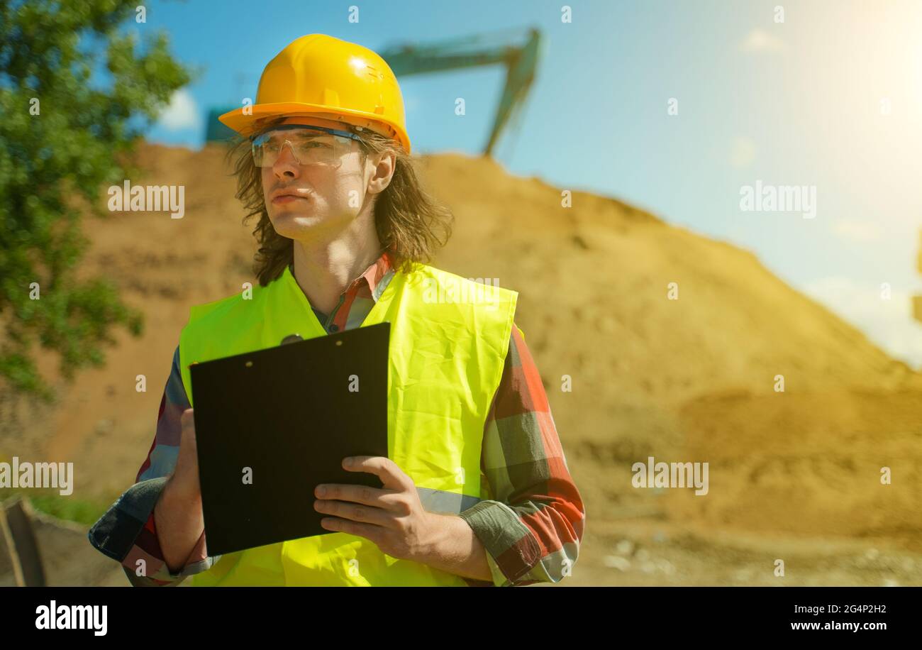 Builder with documents on the background of a road junction ...