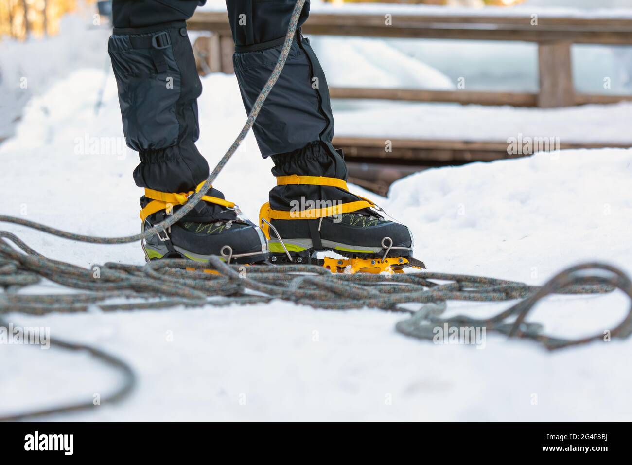 Male ice climber tying a rope to his harness, preparing for a climb ...