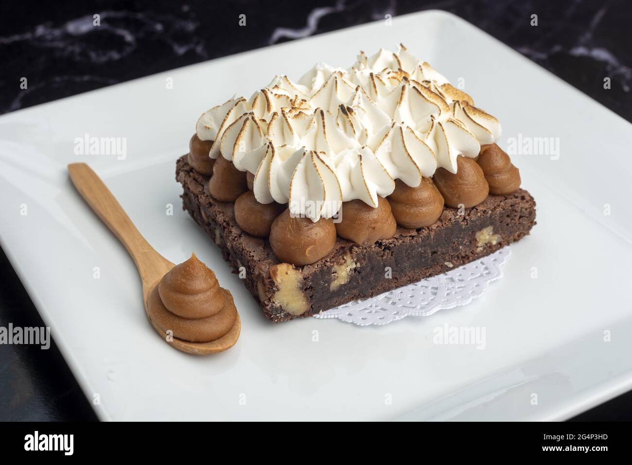 Three-layer cake with chocolate and cream on a large white plate Stock ...