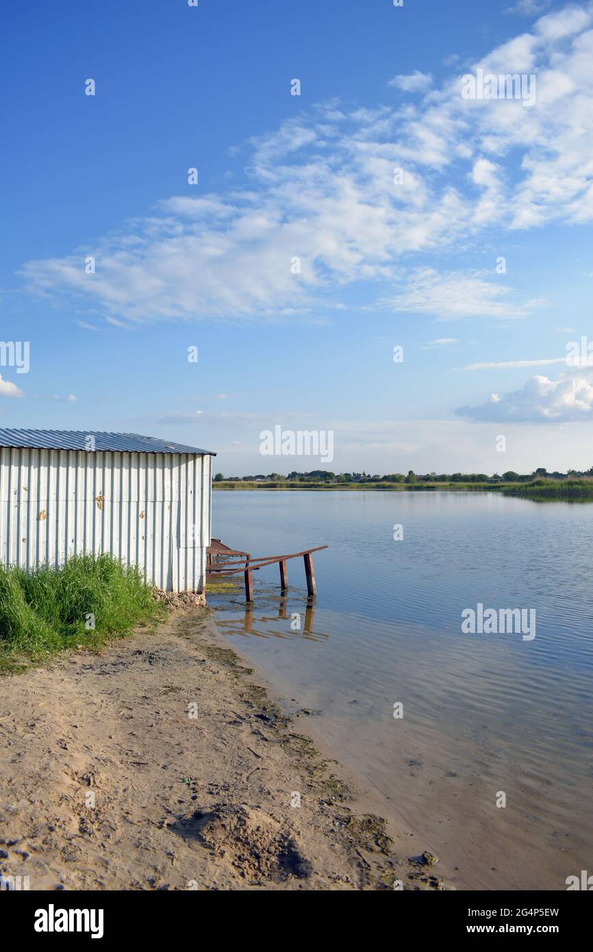A shack and a wooden small pier on the lakeshore Stock Photo - Alamy