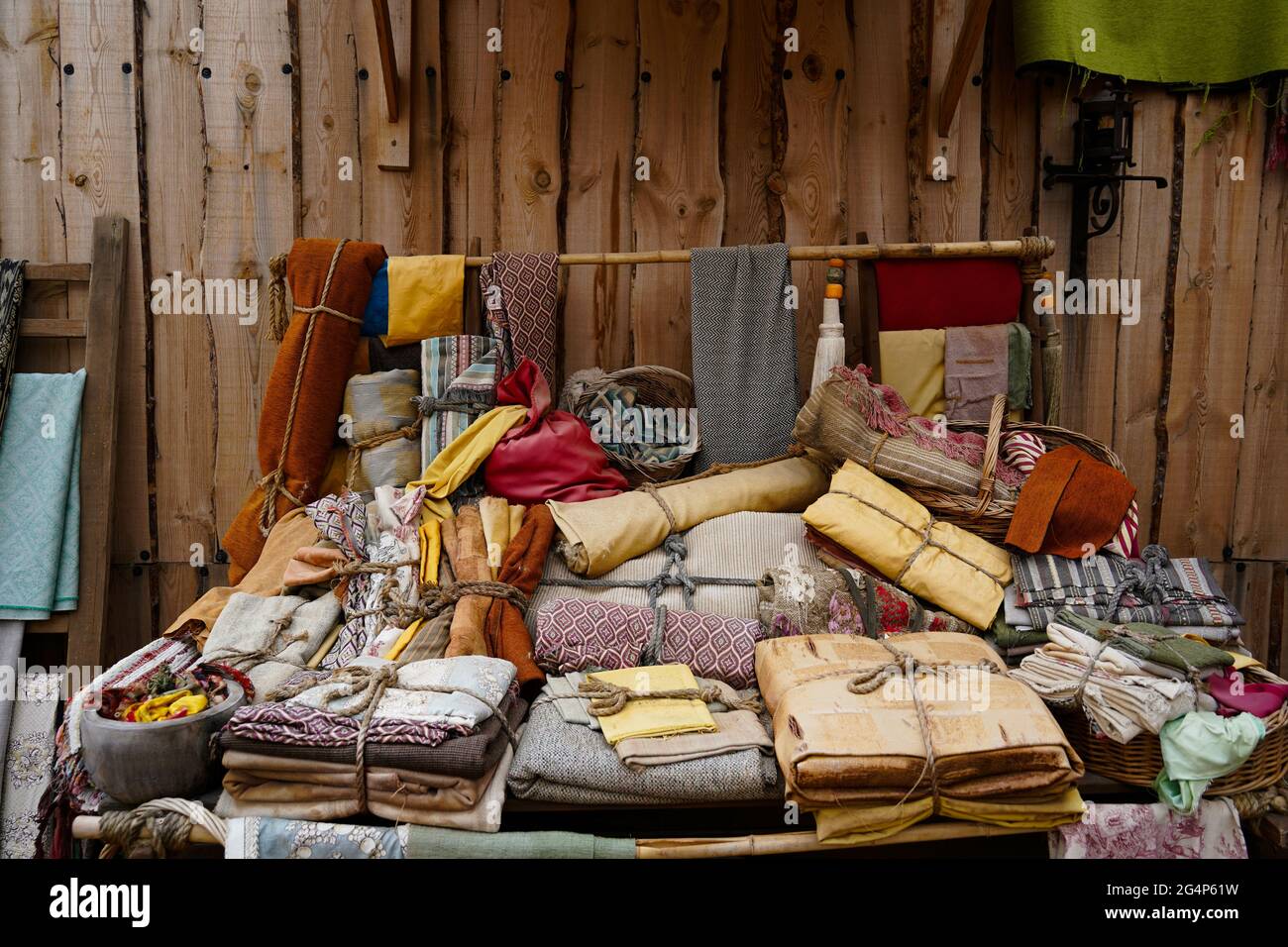 Textile goods in packs by the wooden wall Stock Photo - Alamy