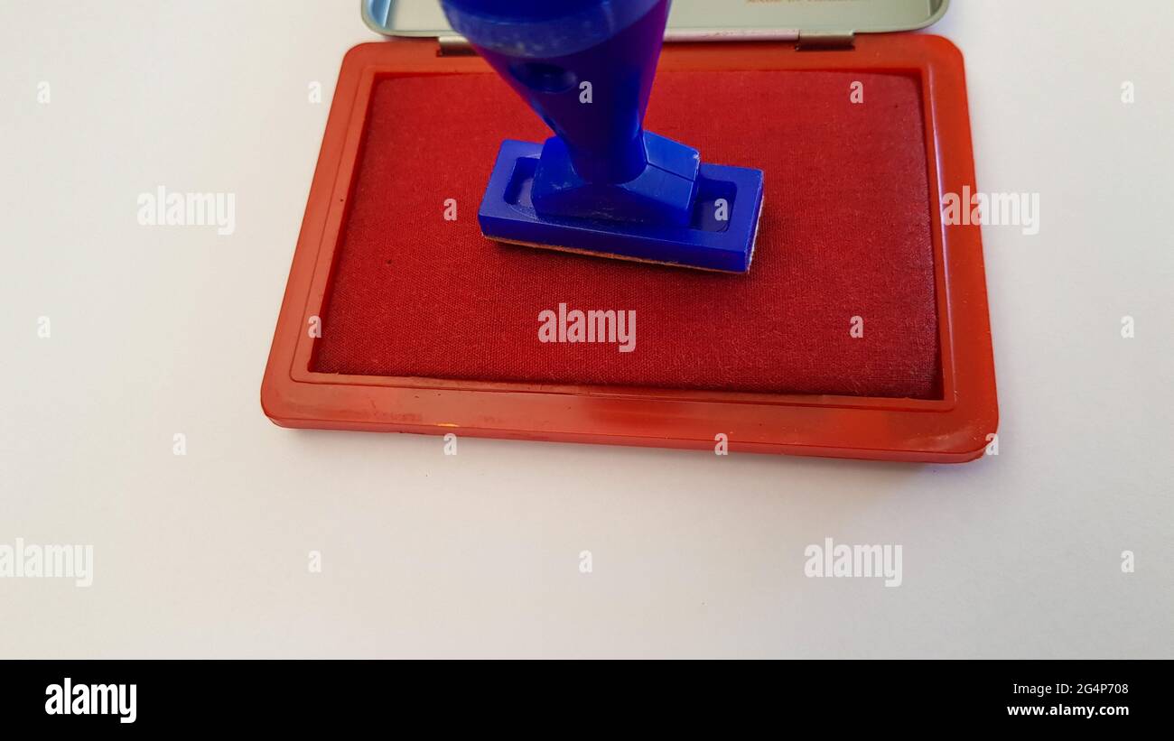 Blue rubber stamp and red ink cartridge on white background Stock Photo ...