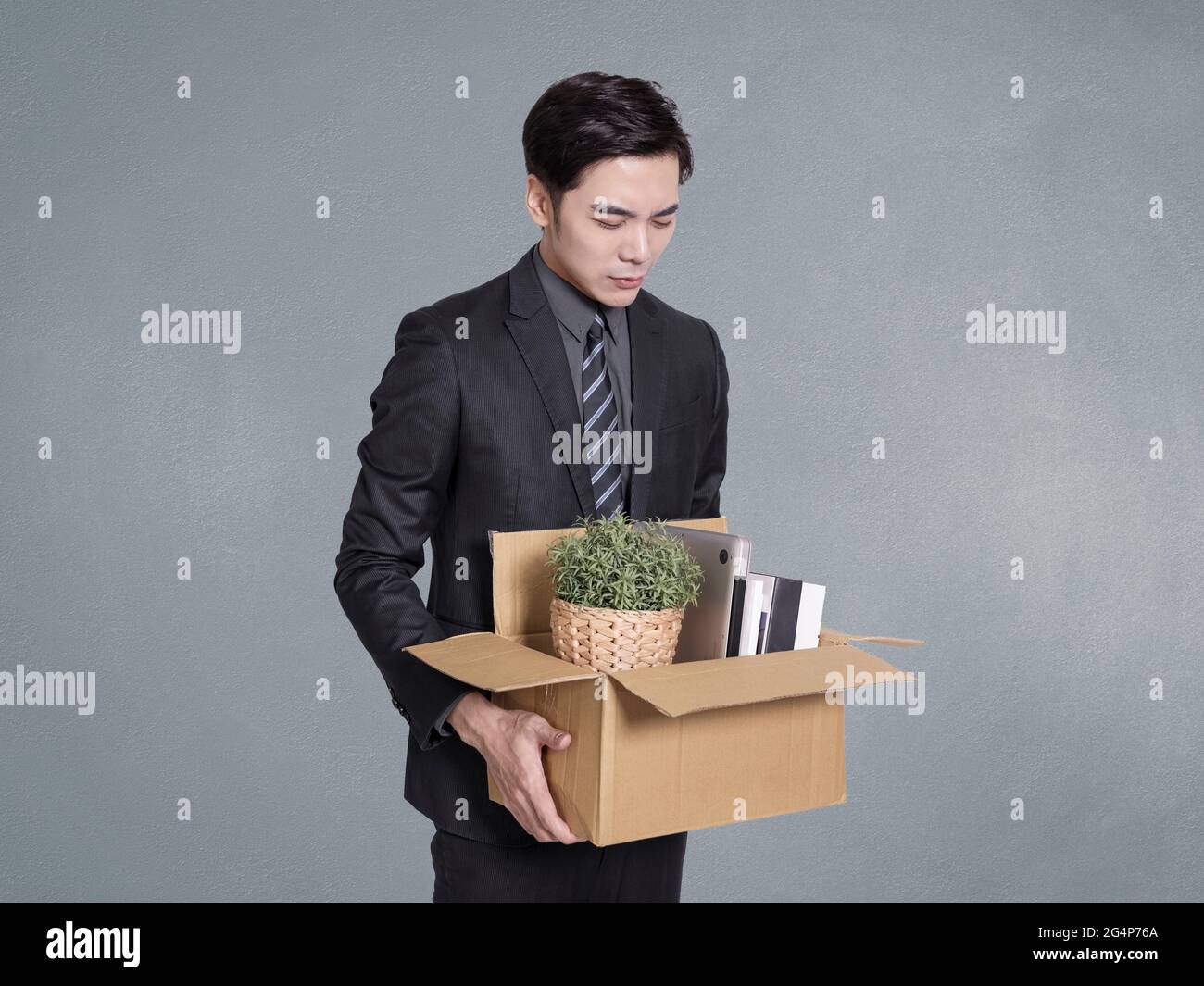 Young business man loss job, holding cardboard box with office supplies ...