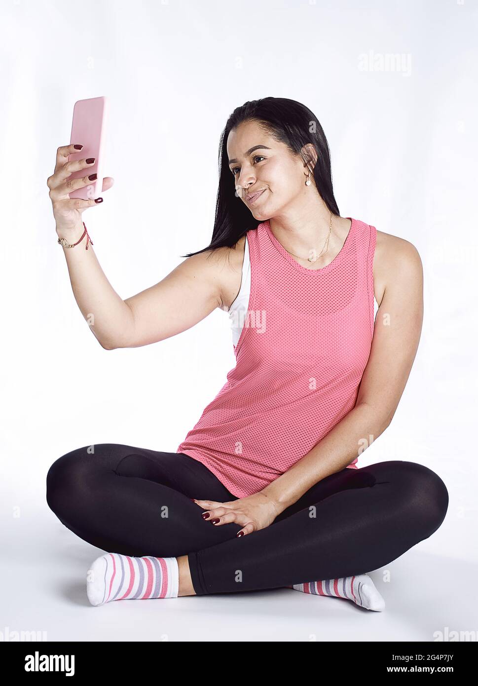 A vertical shot of a Hispanic female taking a selfie isolated on a ...