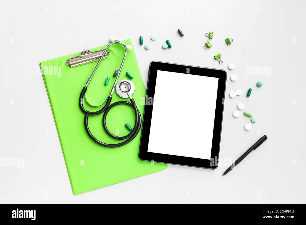 Tablet computer with stethoscope and pills on white background Stock ...