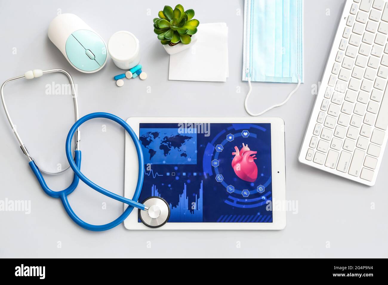Tablet computer with stethoscope and accessories of doctor on grey ...