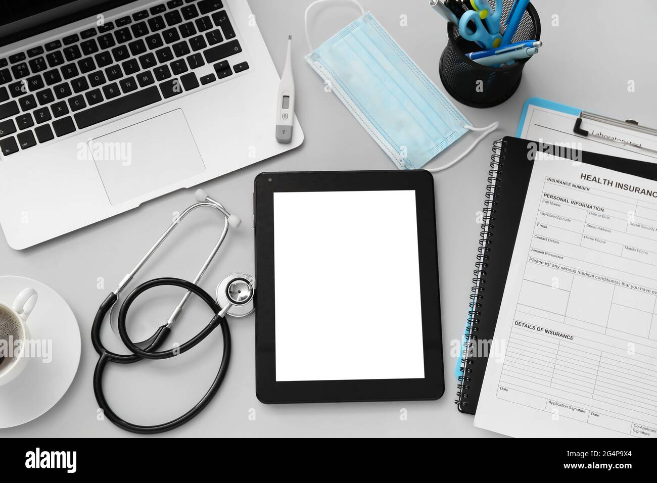 Tablet computer with stethoscope and accessories of doctor on grey ...