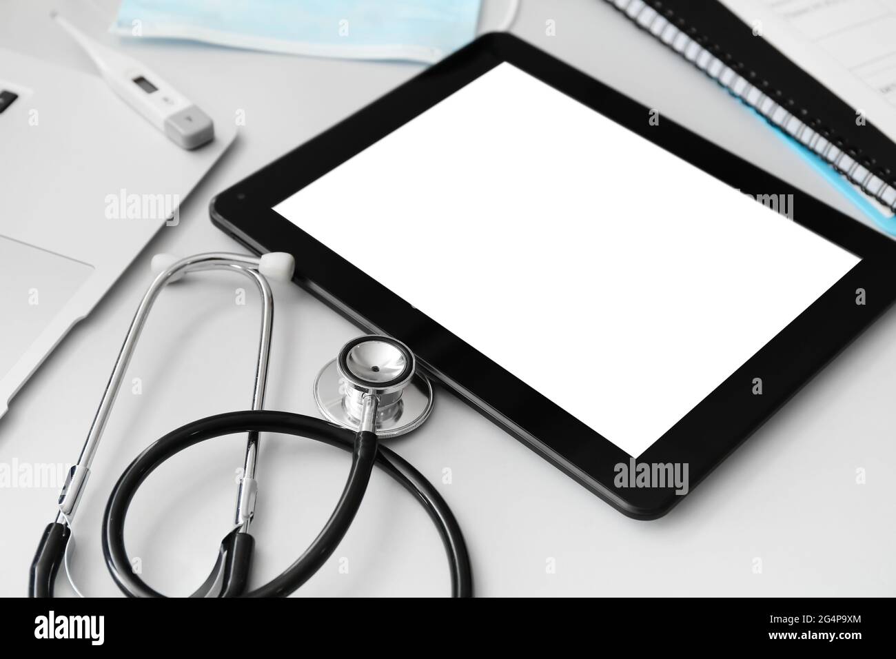 Tablet computer with stethoscope and accessories of doctor on grey ...