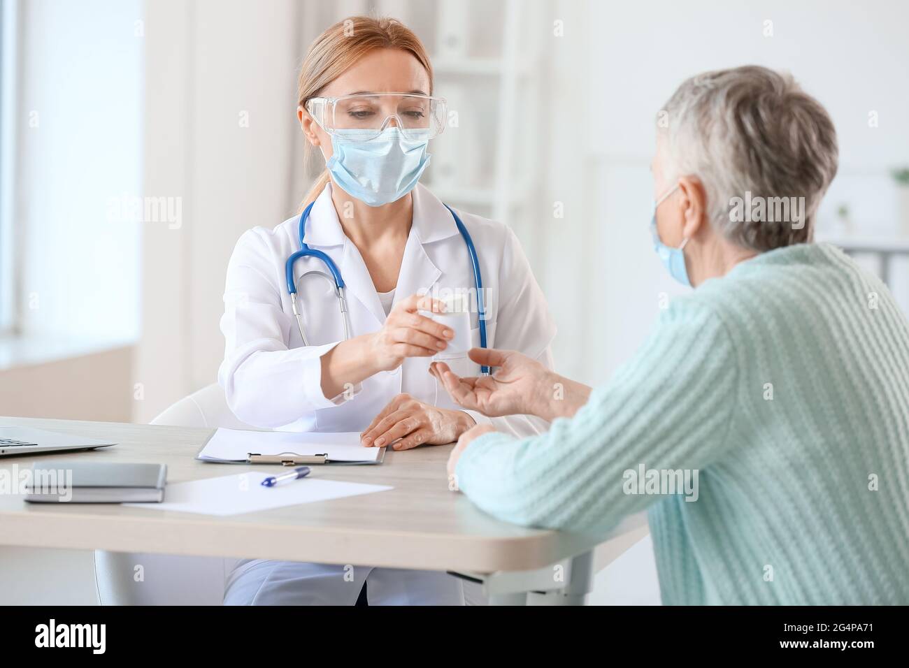 Doctor giving remedy to senior woman in clinic Stock Photo - Alamy