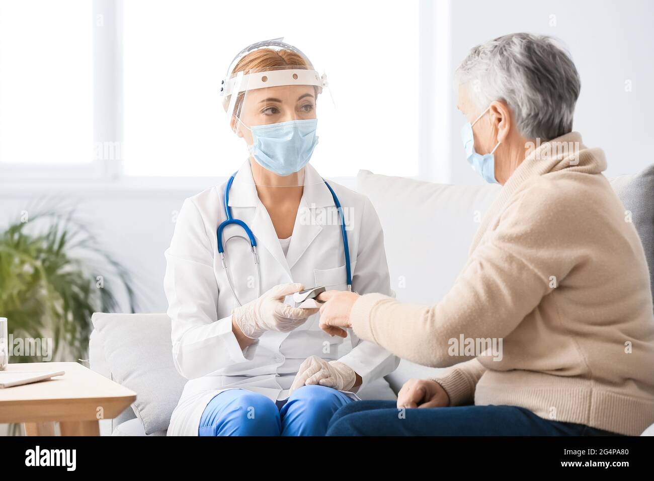 Doctor measuring oxygen saturation level of patient blood at home Stock ...