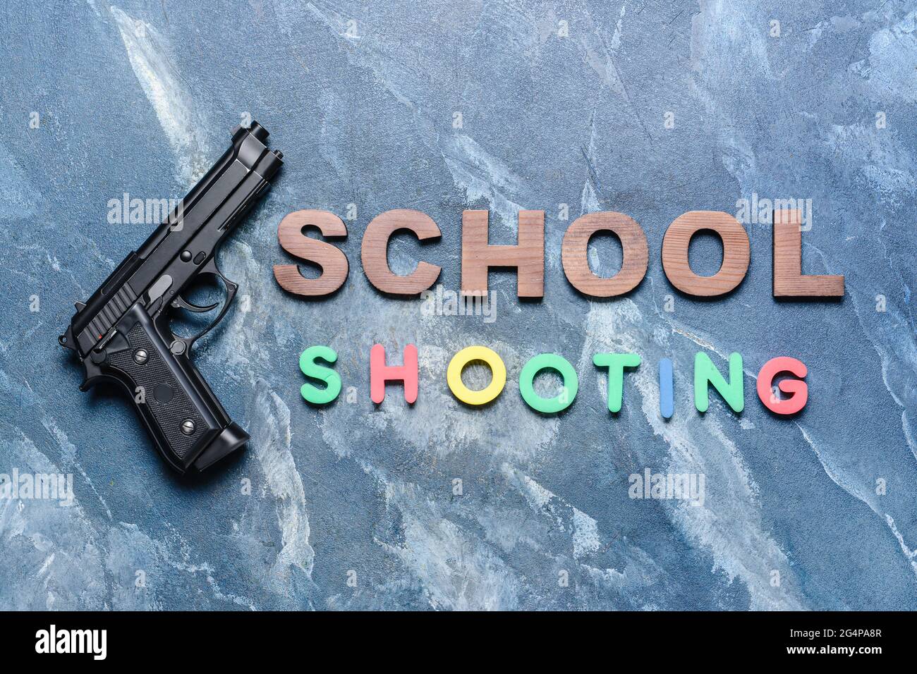 Pistol with text SCHOOL SHOOTING on color background Stock Photo - Alamy