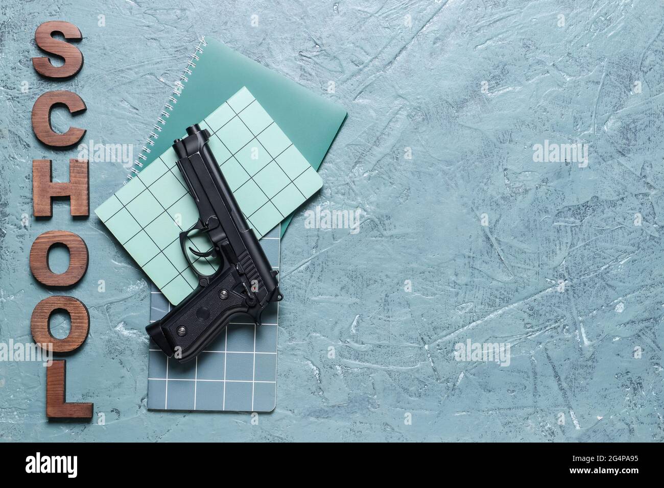 Pistol and notebooks on color background. Concept of school shooting ...