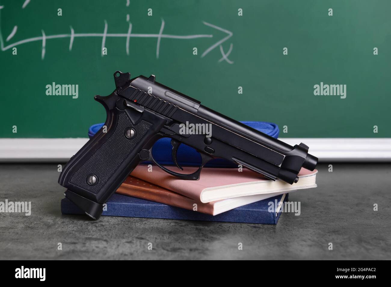 Pistol and books on table in classroom. Concept of school shooting ...