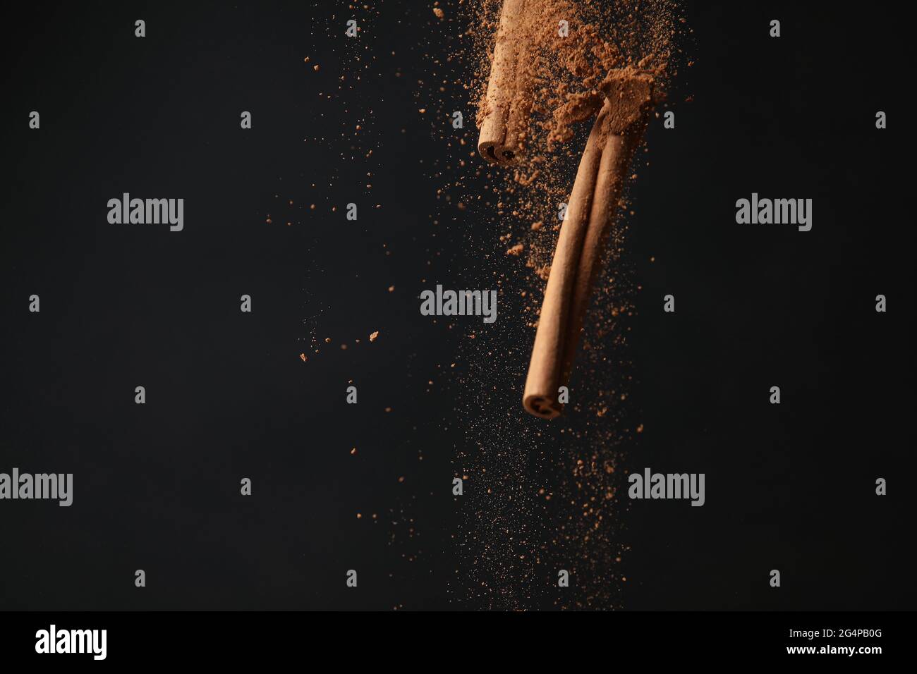 Falling cinnamon sticks and powder on dark background Stock Photo - Alamy