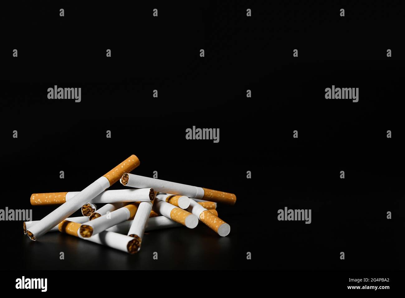 Many cigarettes on dark background Stock Photo - Alamy