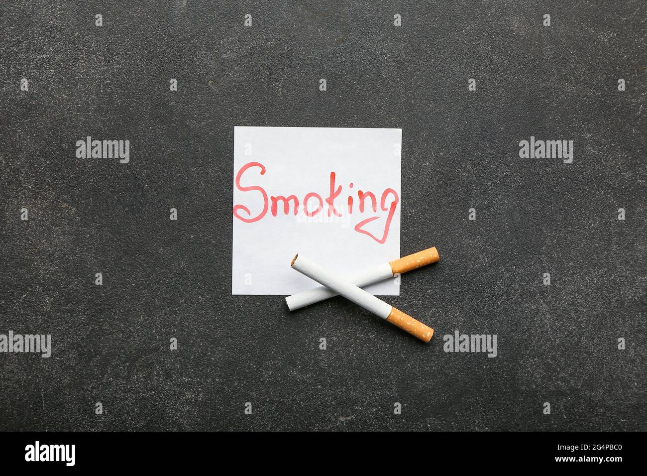 Paper with word SMOKING and cigarettes on dark background Stock Photo ...