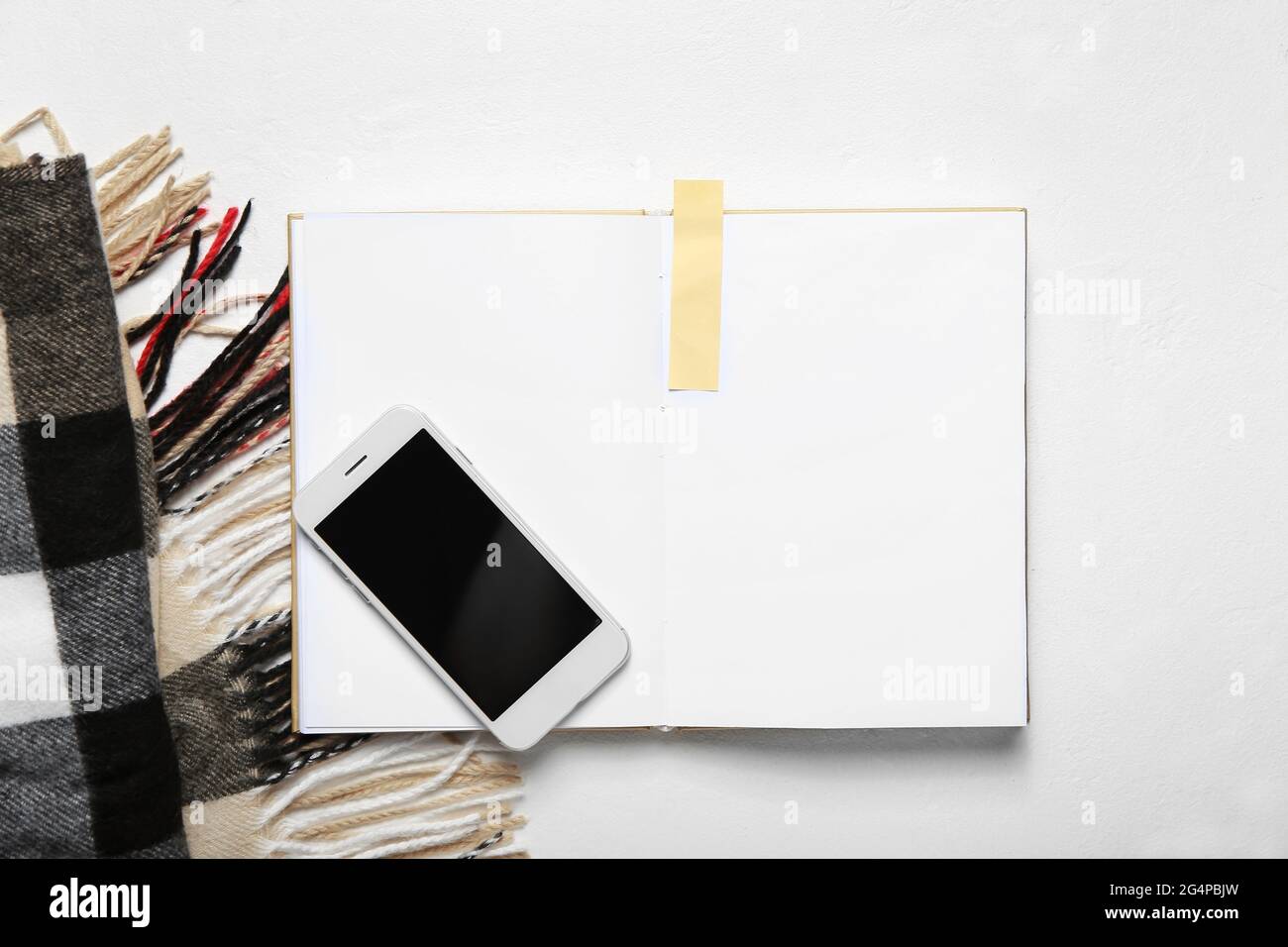 Book with bookmark and mobile phone on white background Stock Photo - Alamy