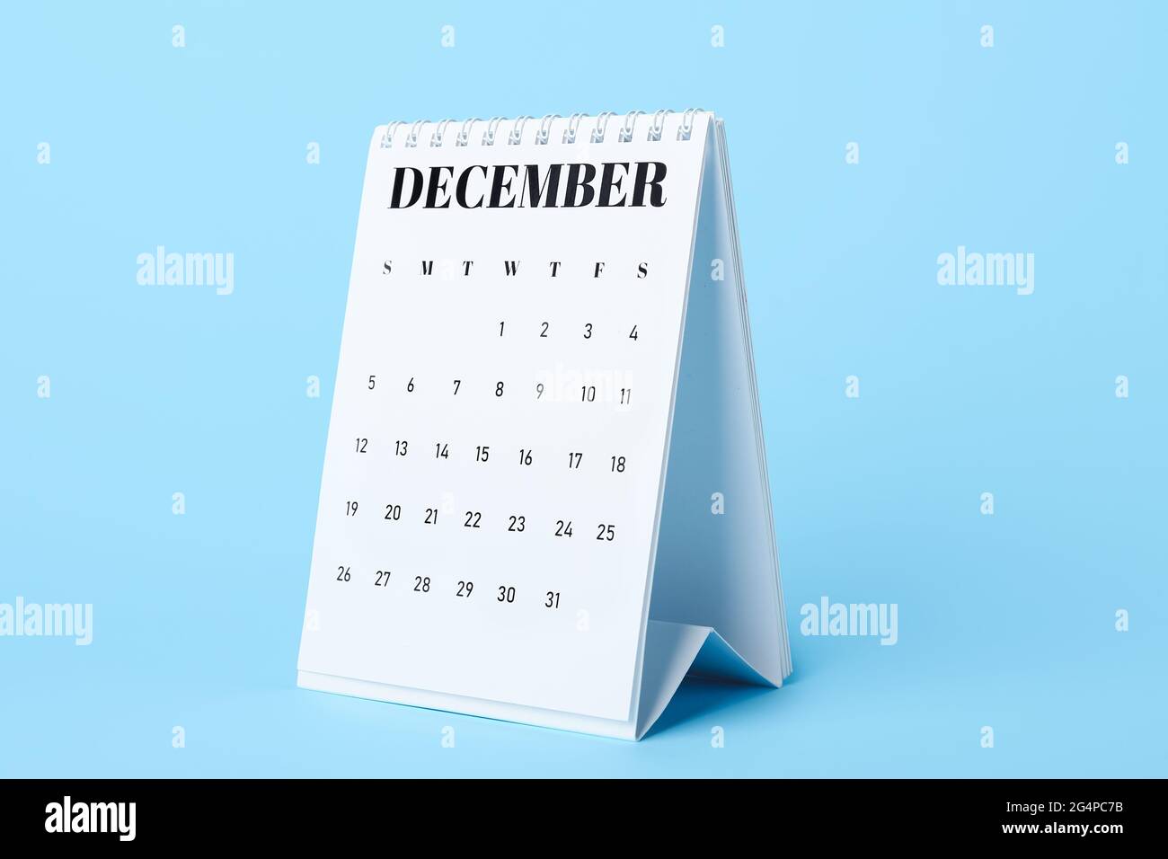 Flip calendar with page of December on color background Stock Photo - Alamy