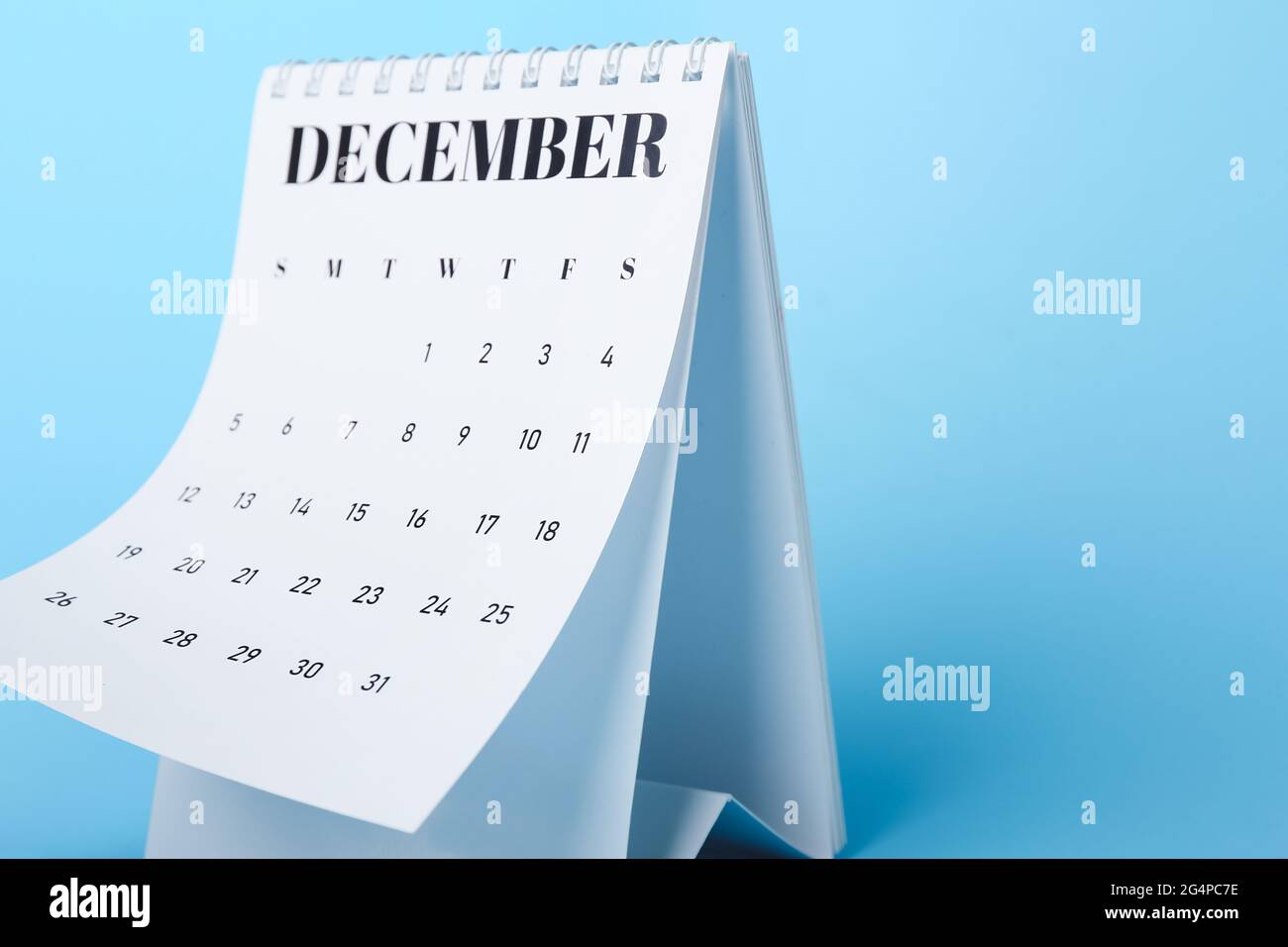 Flip calendar with page of December on color background Stock Photo - Alamy