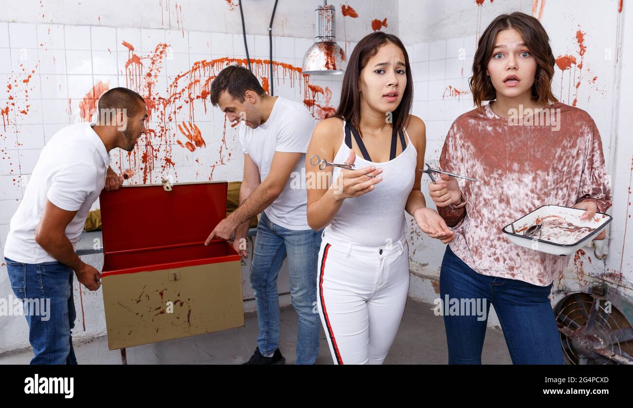 Terrified girls in quest room with bloody traces Stock Photo - Alamy