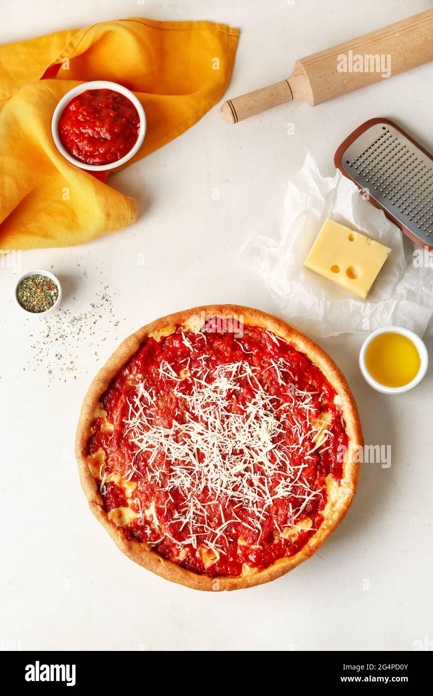 Tasty Chicago-style pizza and ingredients on light background Stock ...