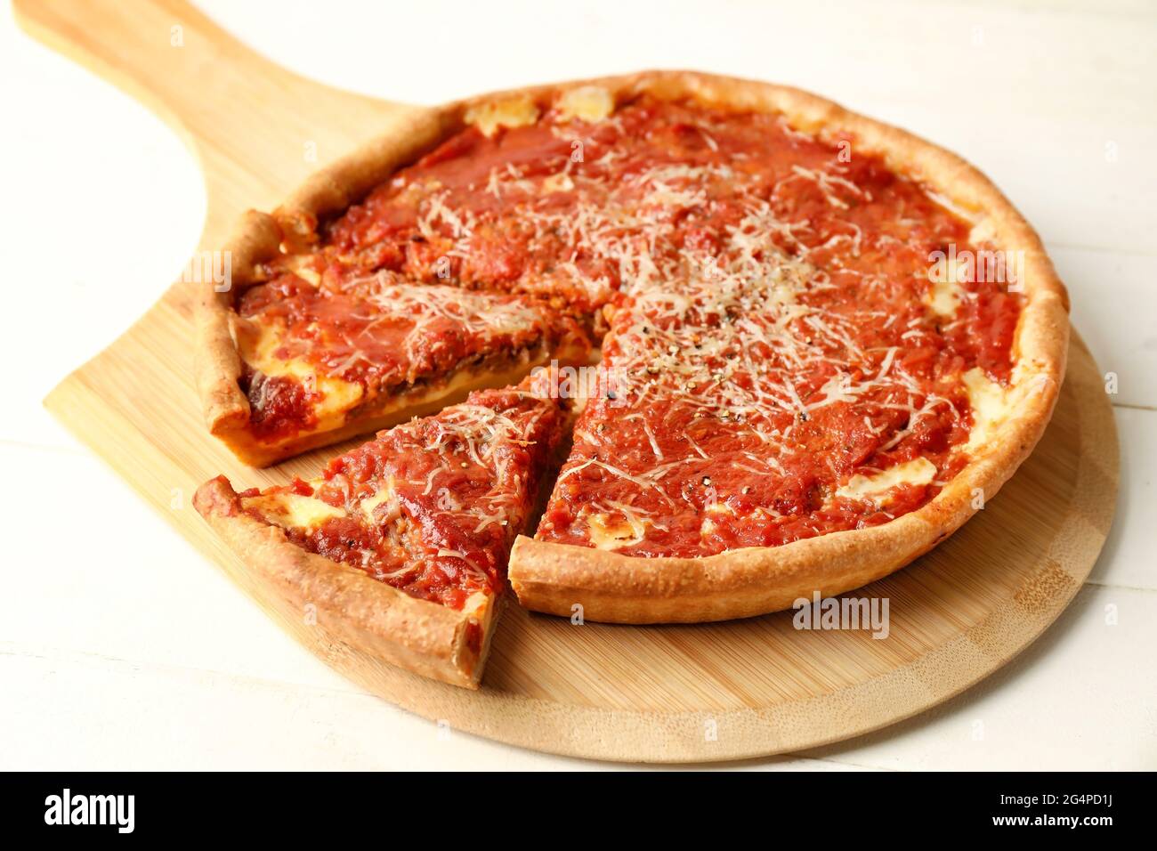 Board with tasty Chicago-style pizza on light wooden background Stock ...
