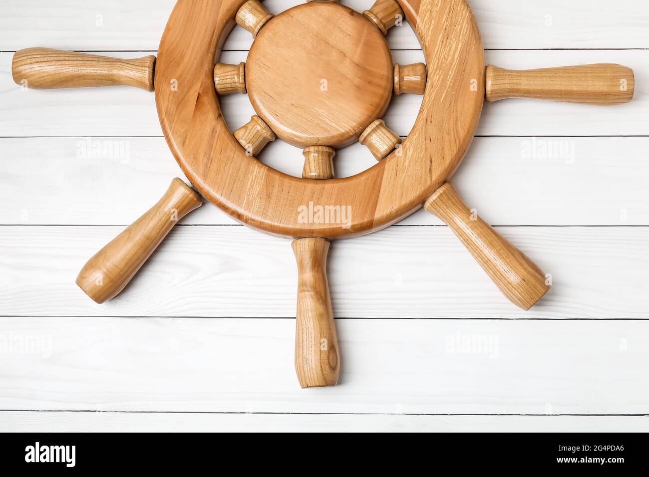 Ship helm on white wooden background Stock Photo - Alamy