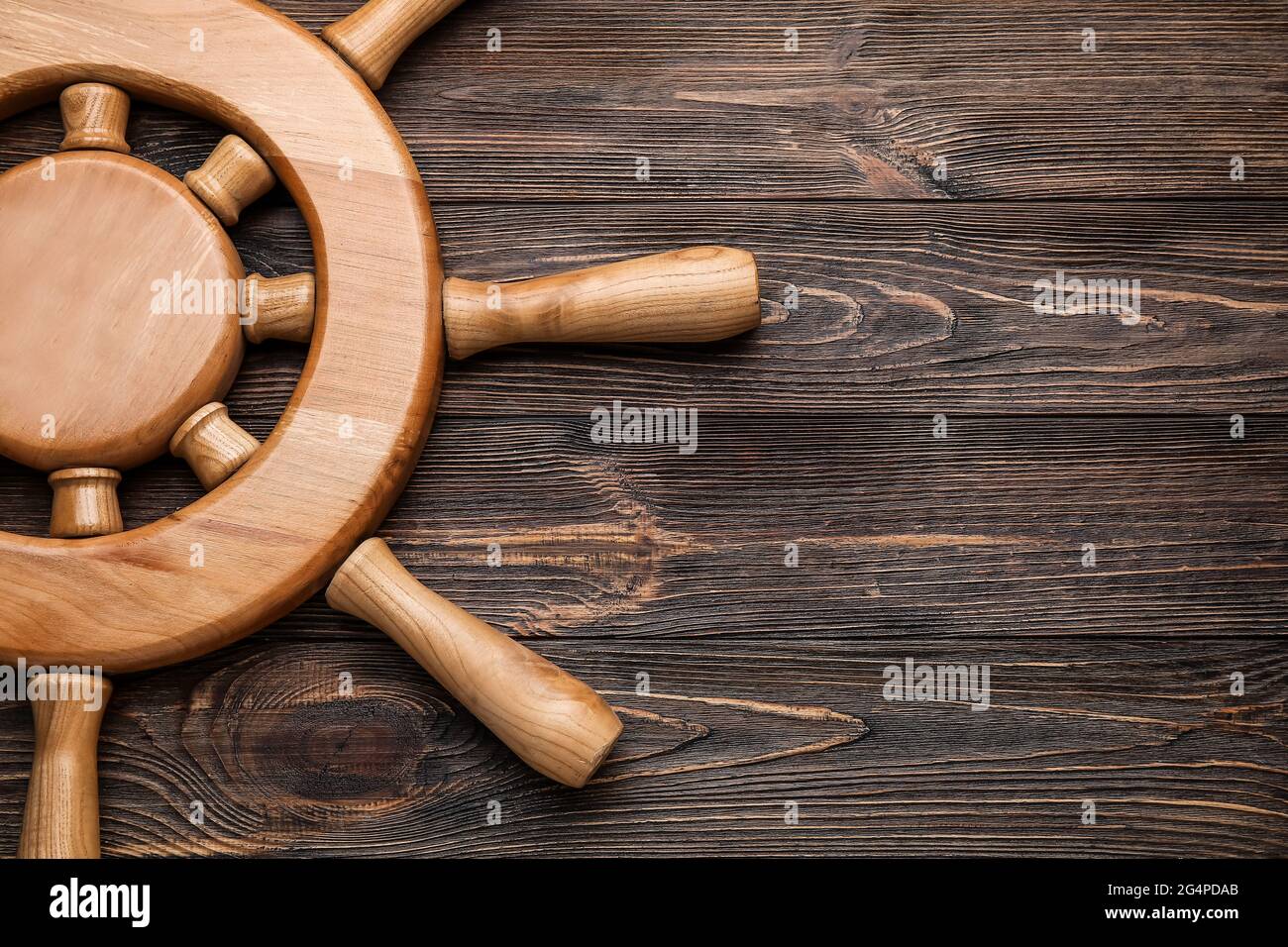Ship helm on wooden background Stock Photo - Alamy