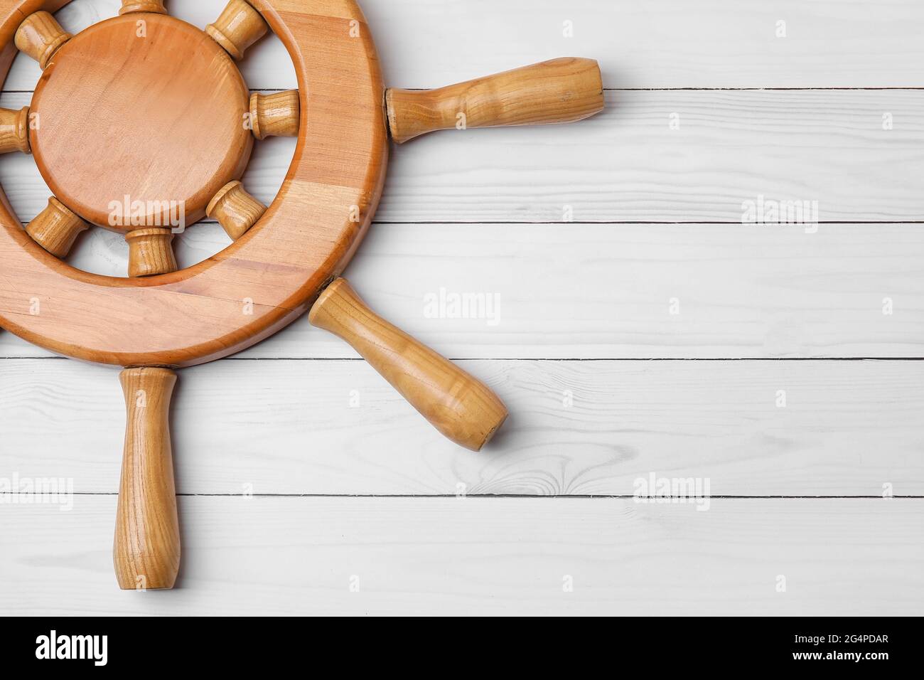 Ship helm on white wooden background Stock Photo - Alamy