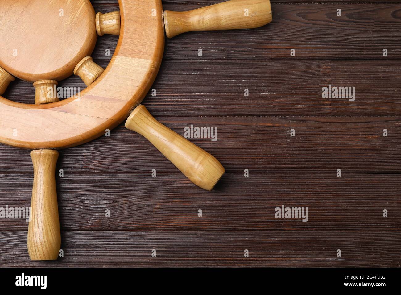 Ship helm on wooden background Stock Photo - Alamy