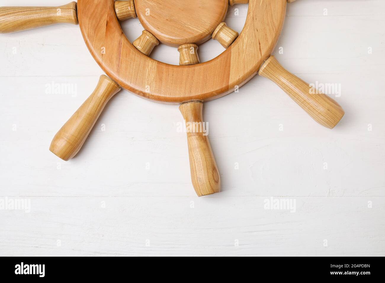 Ship helm on white wooden background Stock Photo - Alamy