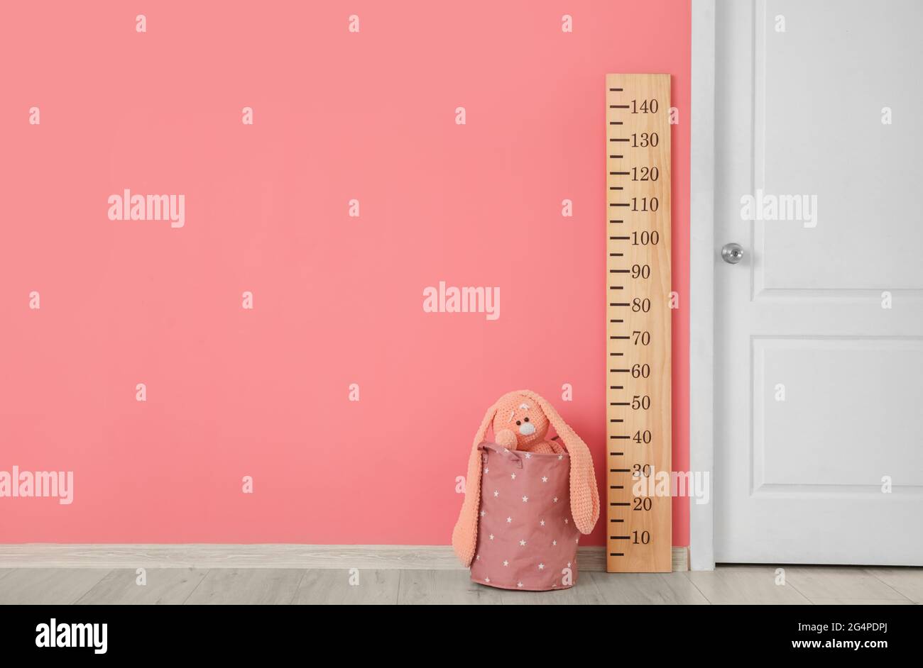 Wooden stadiometer and toy near color wall Stock Photo - Alamy