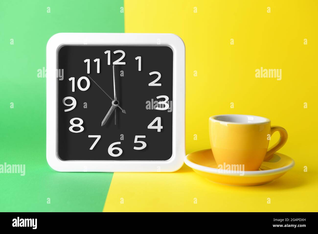 Stylish clock and cup of coffee on color background Stock Photo - Alamy