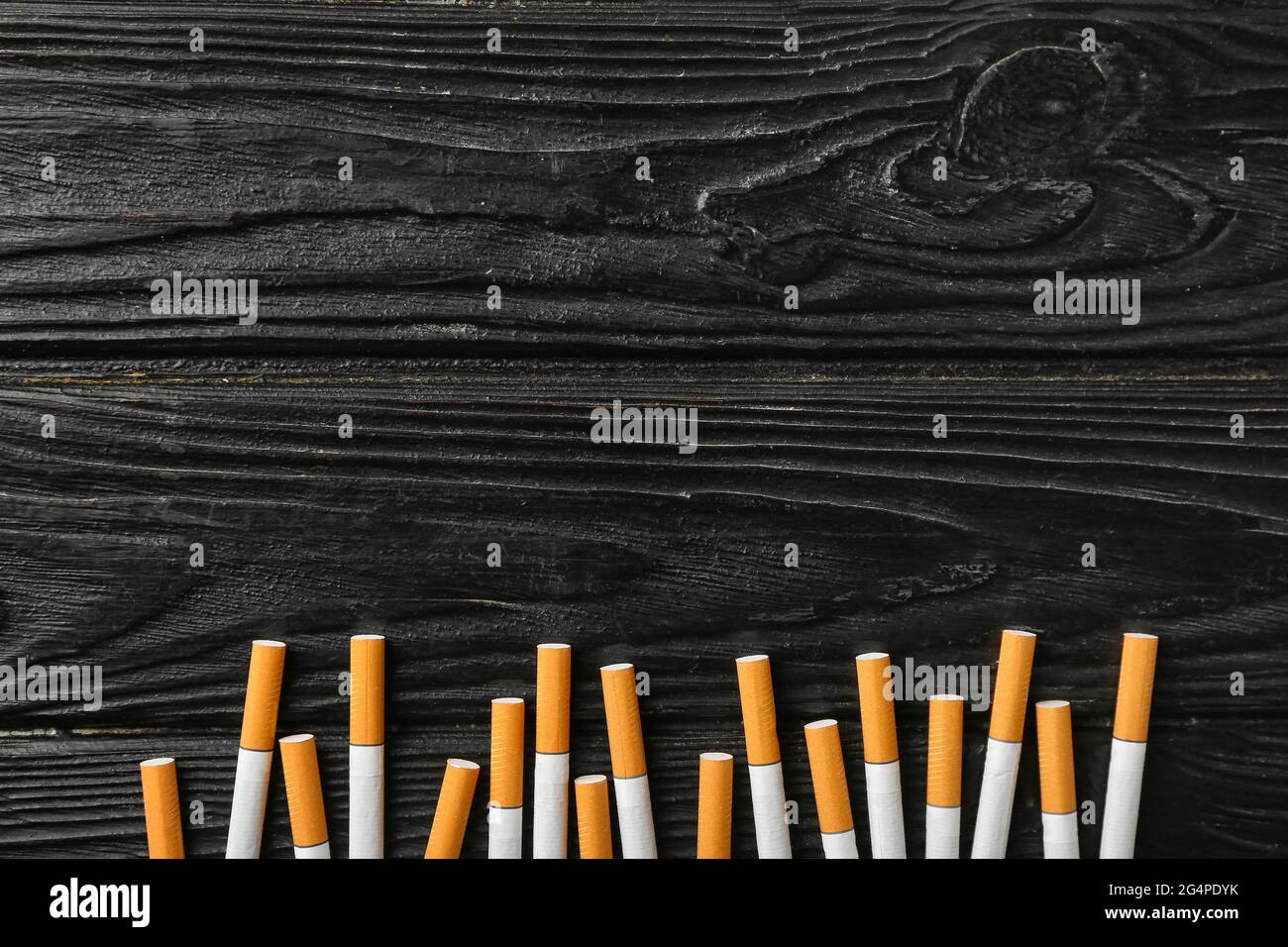 Cigarettes on dark wooden background Stock Photo - Alamy