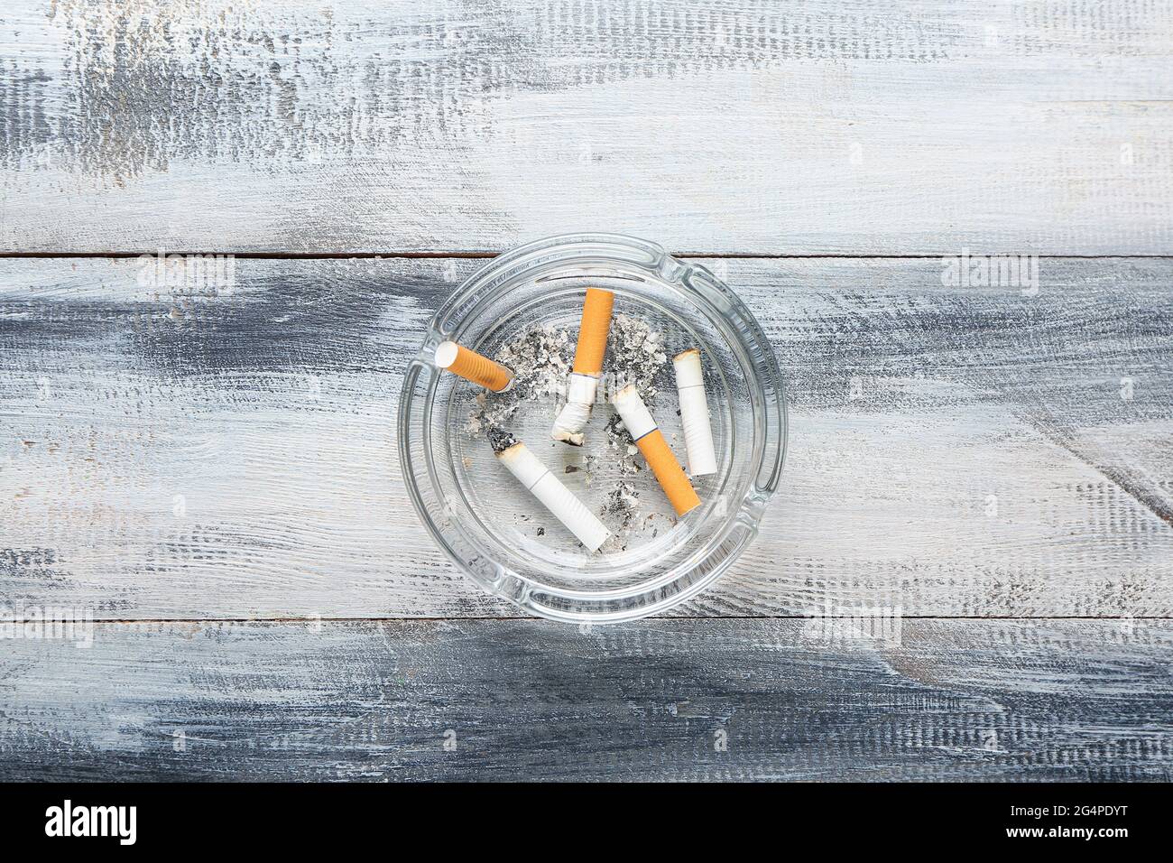 Ash tray with cigarettes on color wooden background Stock Photo - Alamy