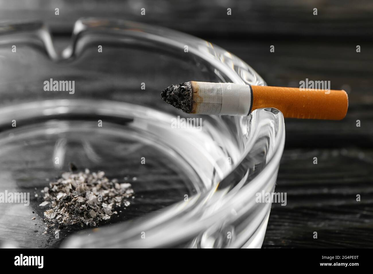 Ash tray and cigarette on dark wooden background, closeup Stock Photo ...