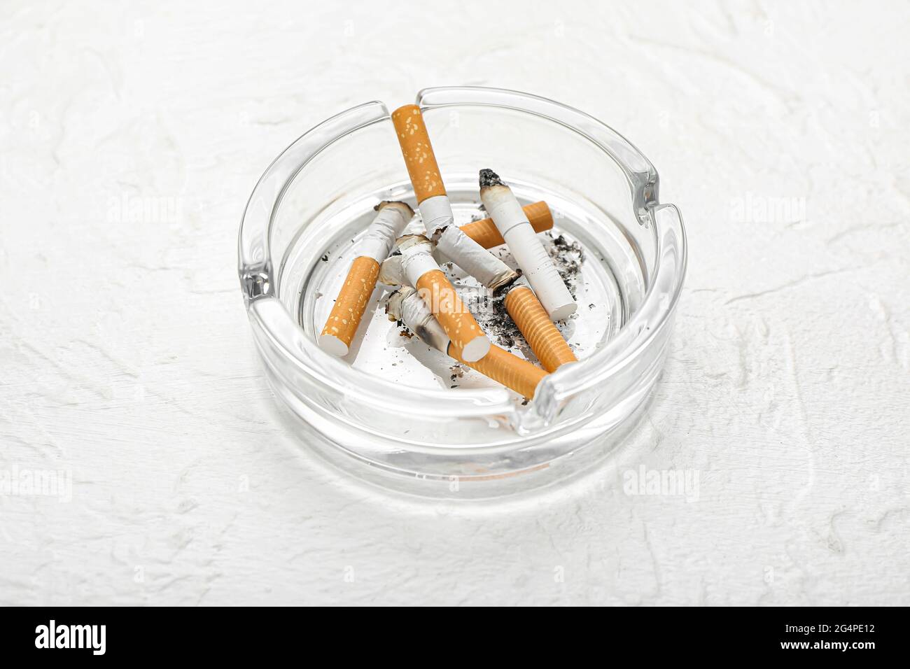 Ash tray with cigarettes on light background Stock Photo - Alamy