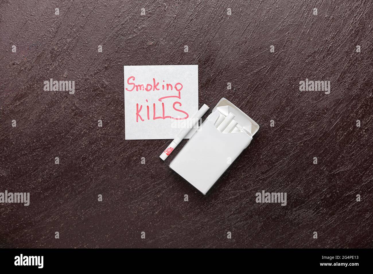 Paper piece with text SMOKING KILLS and cigarettes on dark background ...