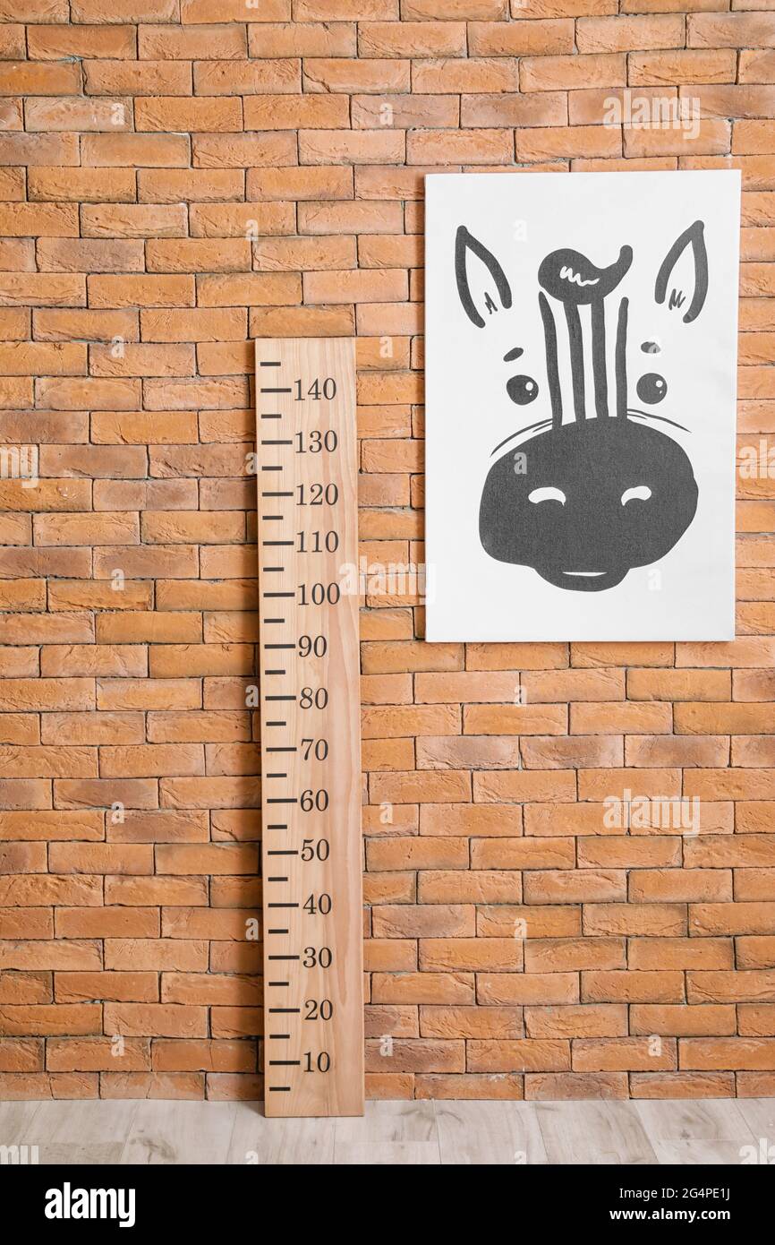 Wooden stadiometer and picture hanging on brick wall Stock Photo - Alamy