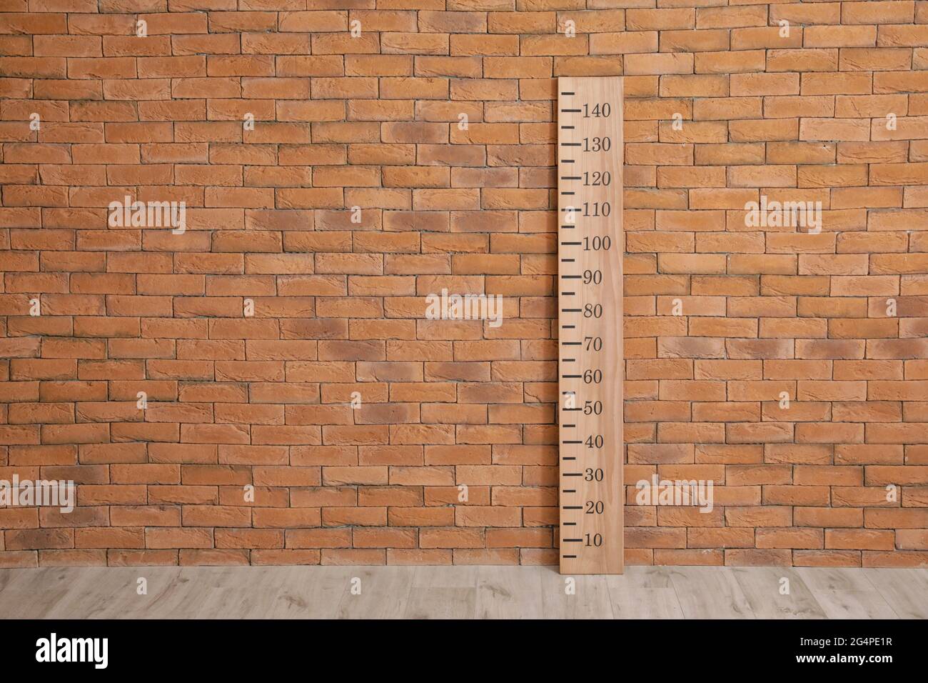Wooden stadiometer near brick wall Stock Photo - Alamy